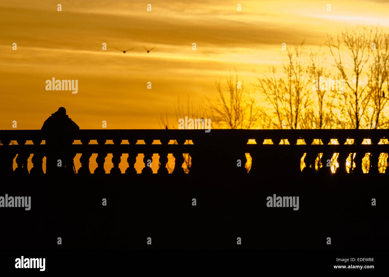 Silhouette and outline man standing on a bridge at sunset Stock Photo ...