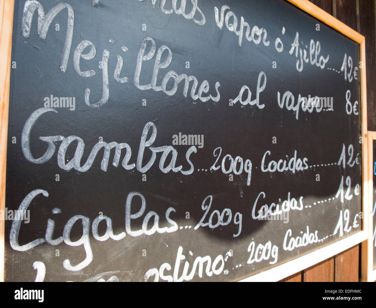 black placards spanish handwritten in brown wood wall with typical menu ...