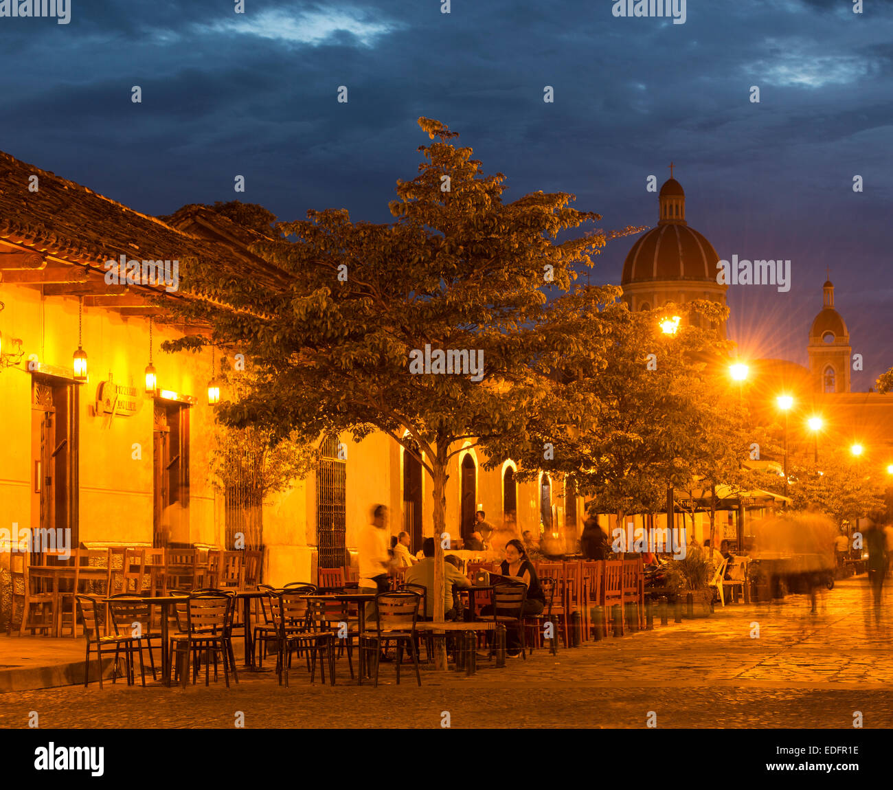 Dusk street scene of diners eating on the streets of historic colonial ...