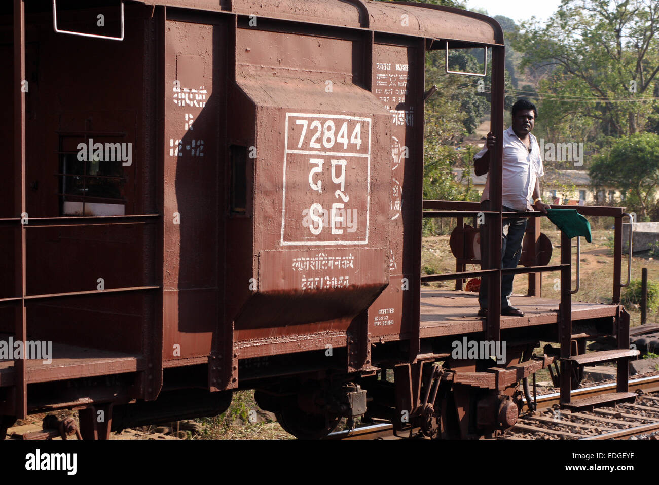 Signal man standing on a train on the rails between Koraput and Araku ...