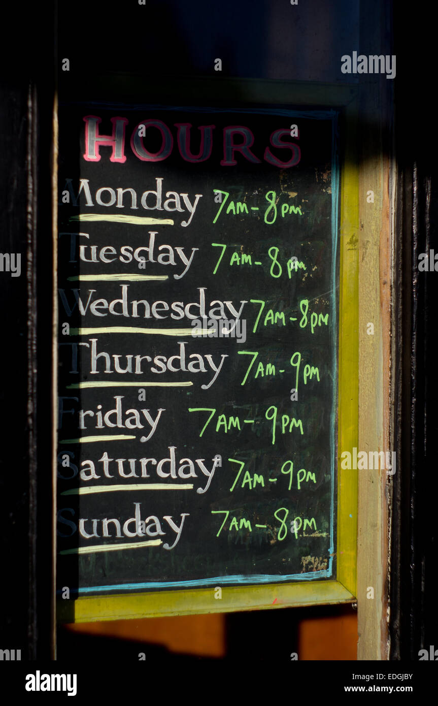 A chalked list of shop hours Stock Photo - Alamy