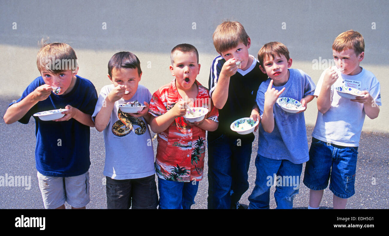 Six first-grade boys eating ice cream at a spring birthday party at at ...