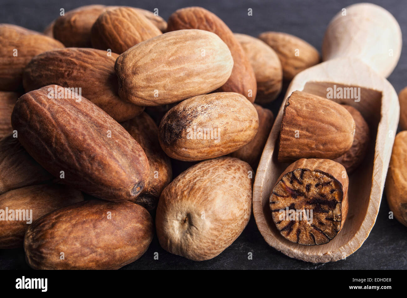 A bunch of nutmeg on black stone background Stock Photo - Alamy