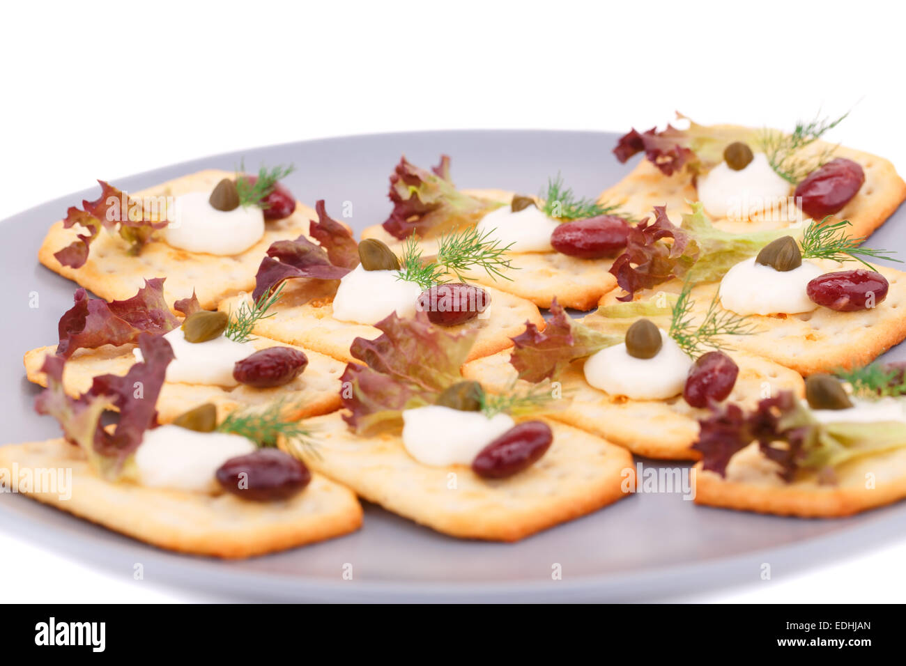 Crackers with red kidney beans and cream on gray plate Stock Photo - Alamy