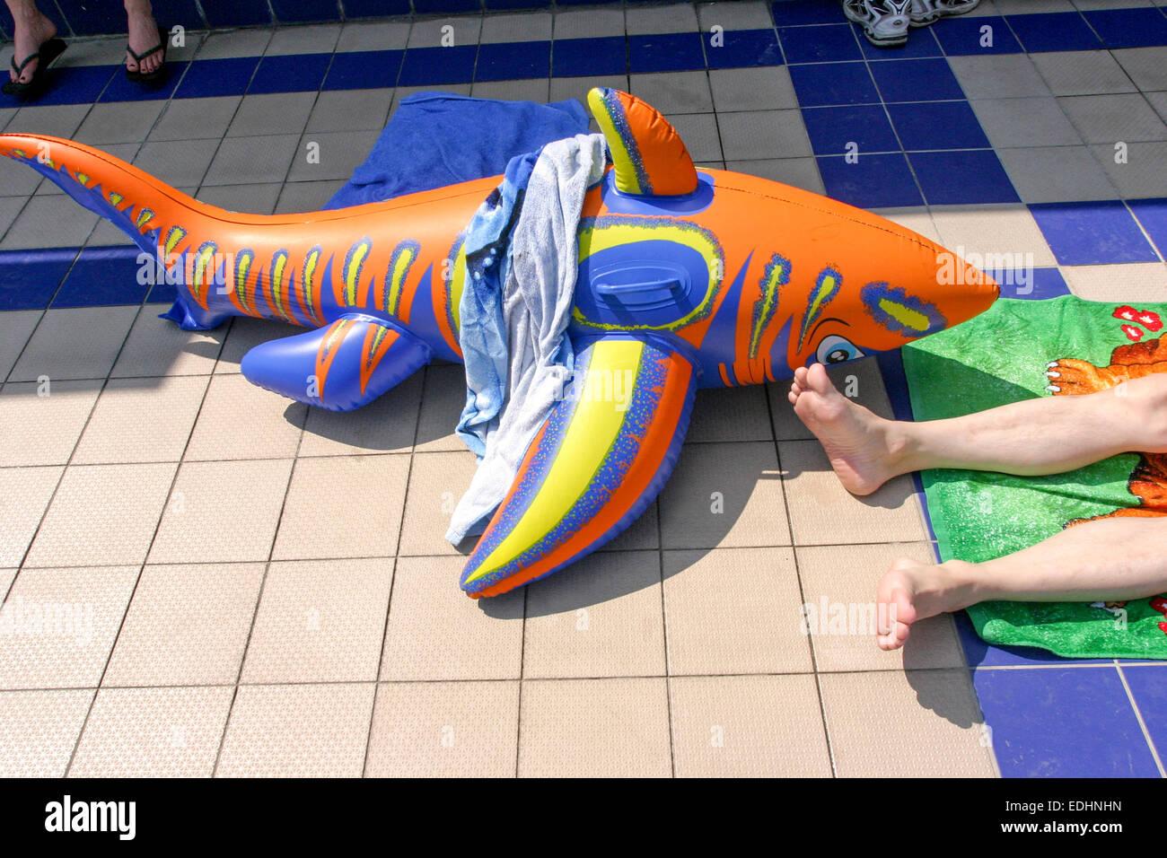 Shark attack to sunbathing man legs at the swimming pool, inflatable ...