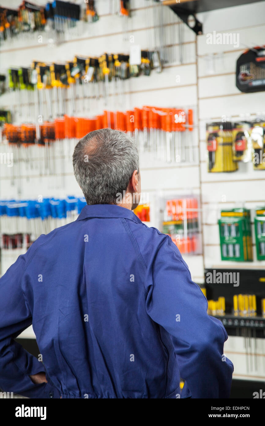 Worker Looking At Tools In Hardware Store Stock Photo - Alamy