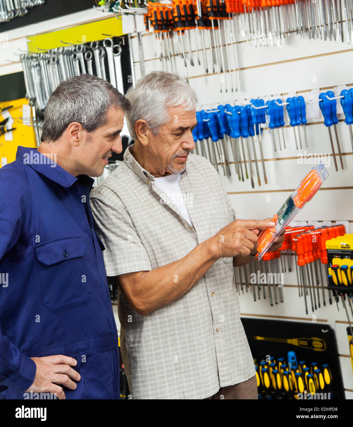 Customer Examining Packed Screwdriver While Vendor Looking At Stock ...