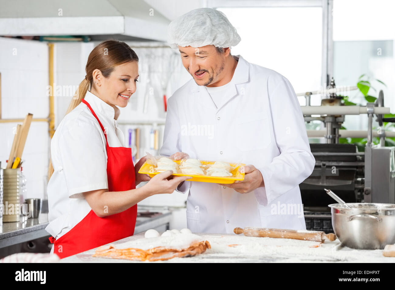 Smiling Chefs Holding Pasta Tray In Kitchen Stock Photo - Alamy
