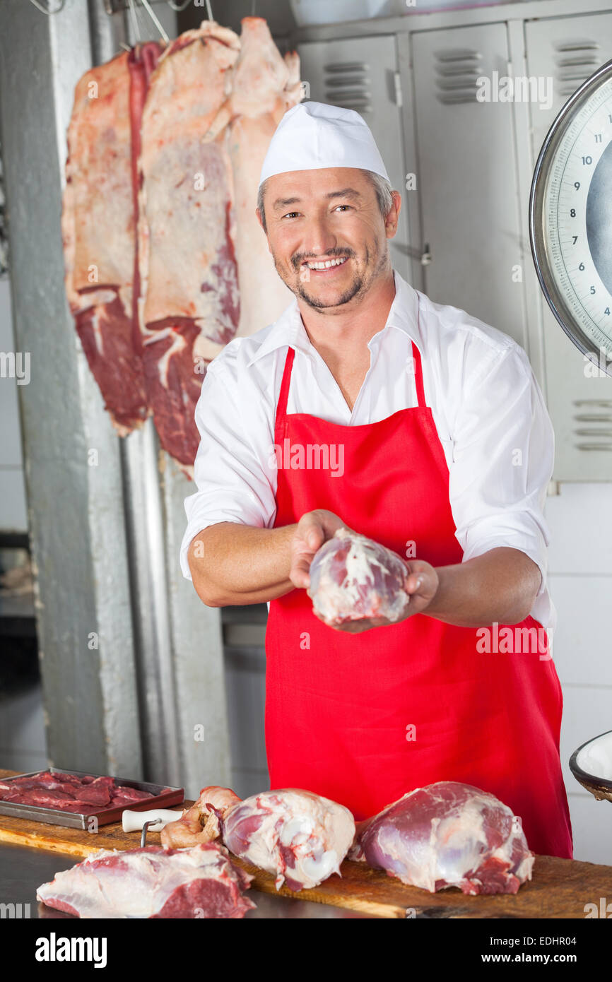 Smiling Male Butcher Holding Meat In Butchery Stock Photo - Alamy