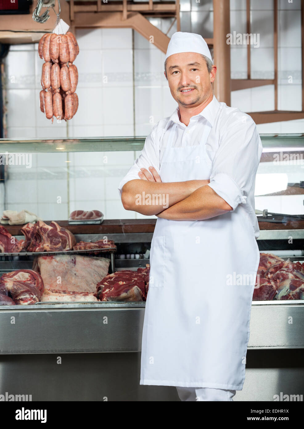 Butcher Standing Arms Crossed In Butchery Stock Photo - Alamy