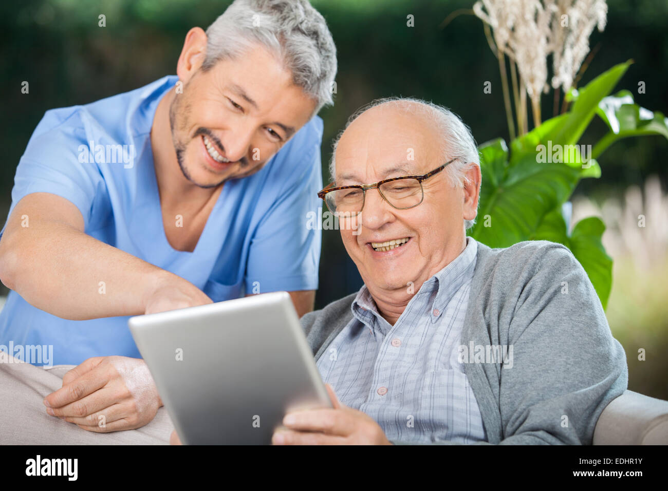Nurse And Senior Man Enjoying While Using Tablet Computer Stock Photo ...