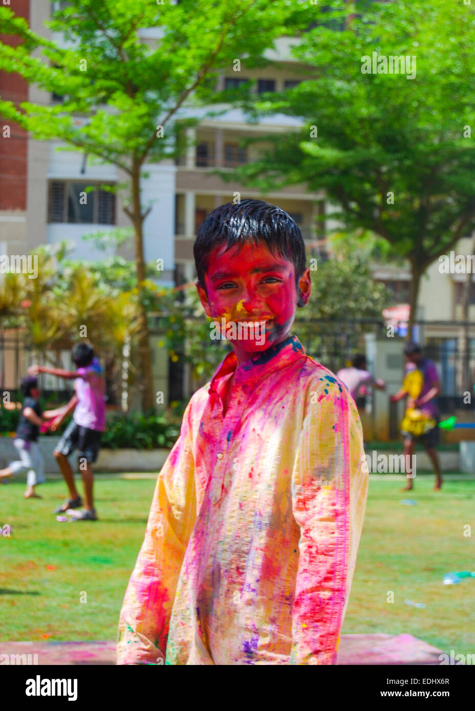 A young Indian boy playing with powder colors & water during the spring ...