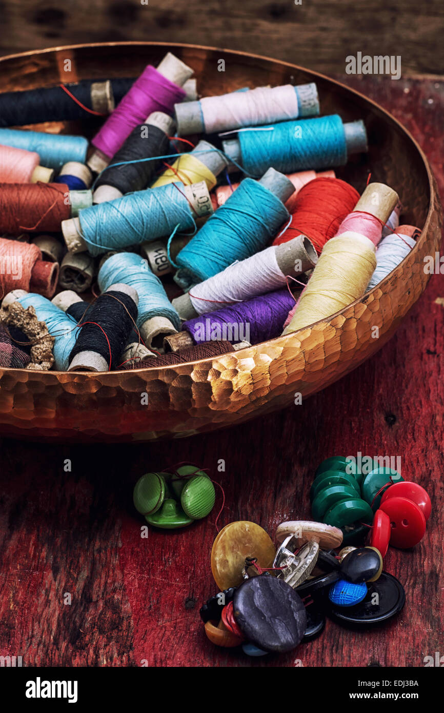 coils of different sewing threads in bronze bowl Stock Photo - Alamy