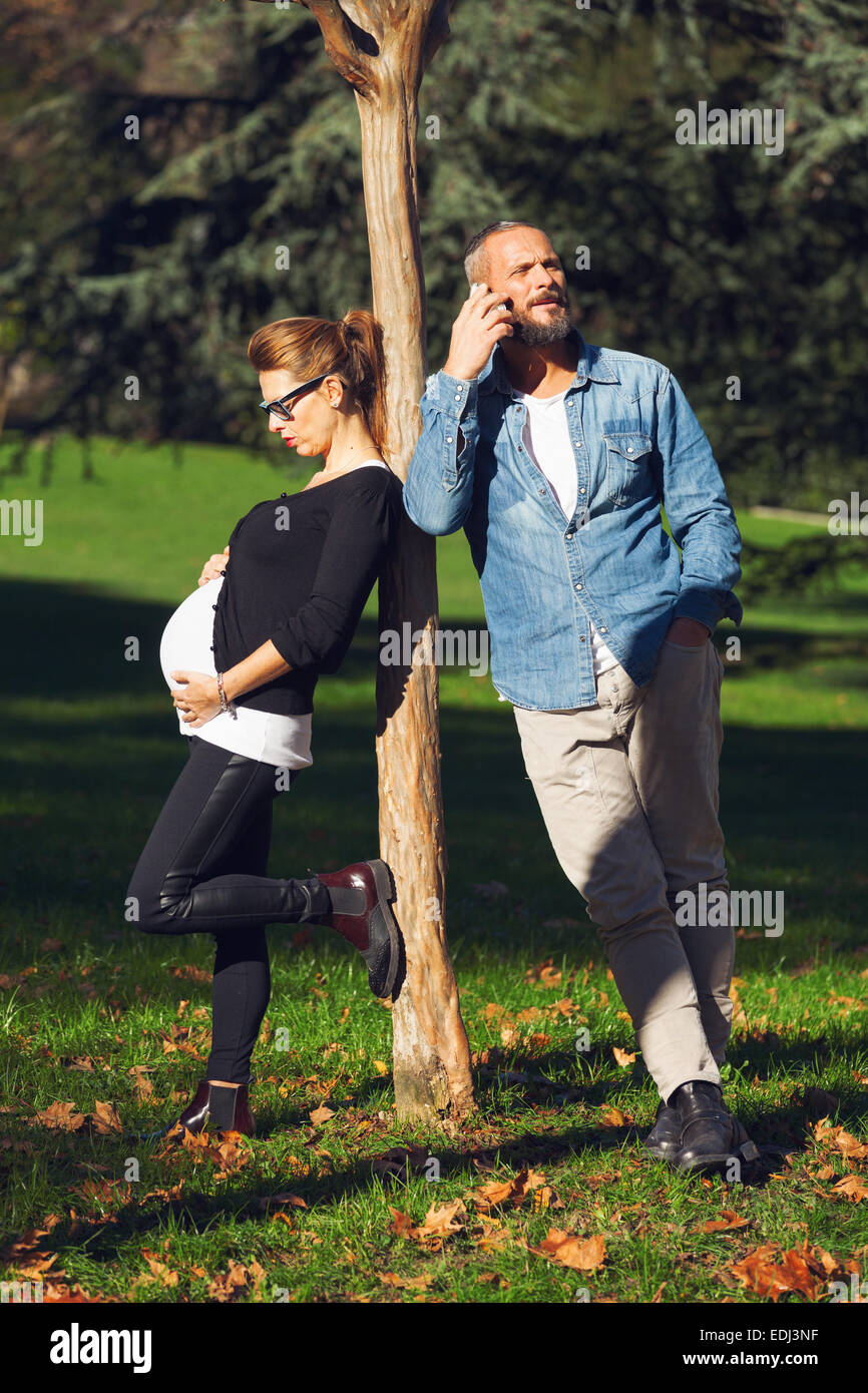 Couple who is expecting a child relaxes, he makes a call Stock Photo ...