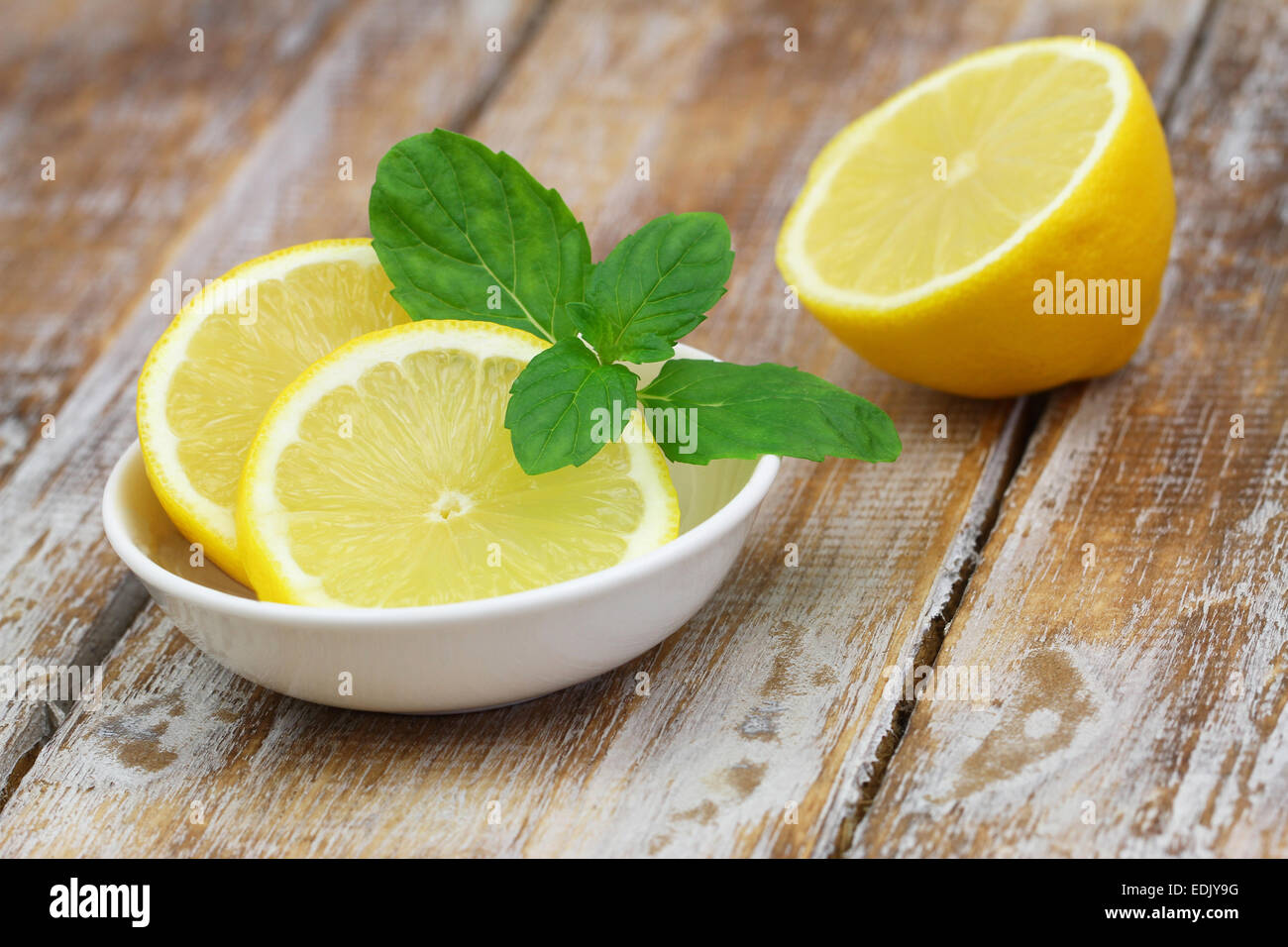 Lemon garnished with organic mint leaves on rustic wooden surface Stock ...