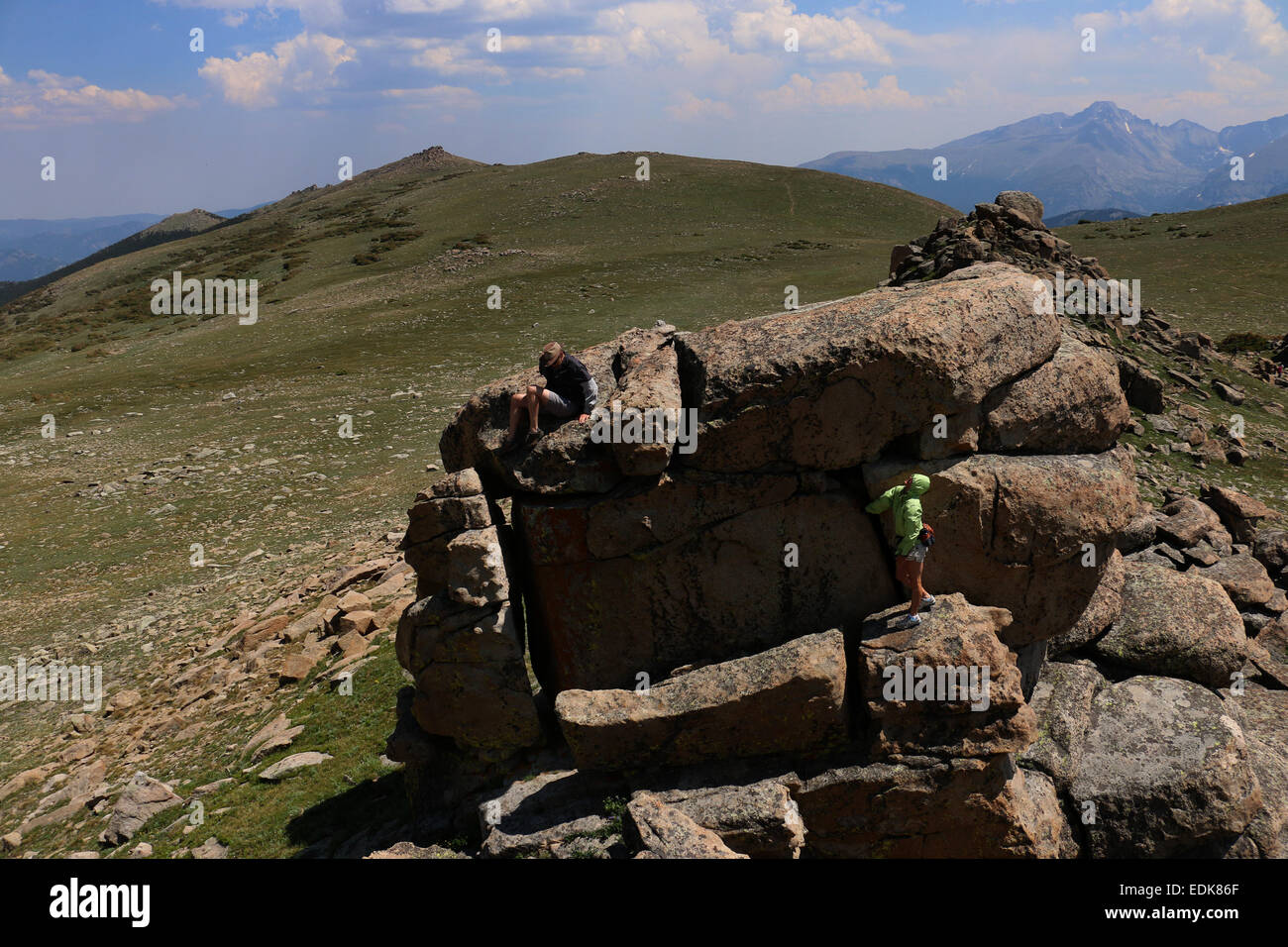 hikers bouldering on weathered granite cliff Rocky Mountain National ...