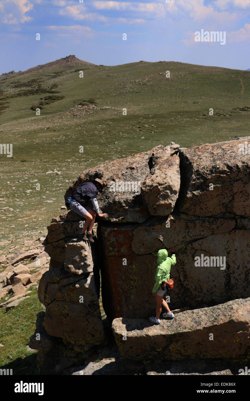 hikers bouldering on weathered granite cliff Rocky Mountain National ...