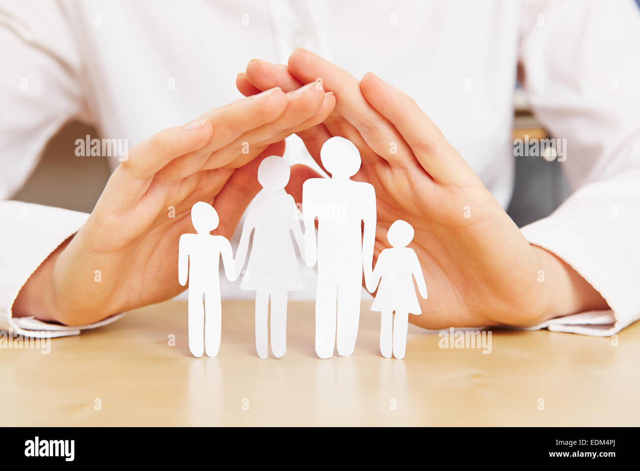 Female hands protecting family with children made of paper Stock Photo ...
