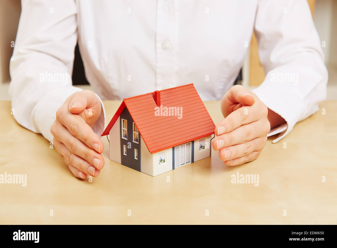 Female hands protecting house as symbol for real estate insurance Stock ...