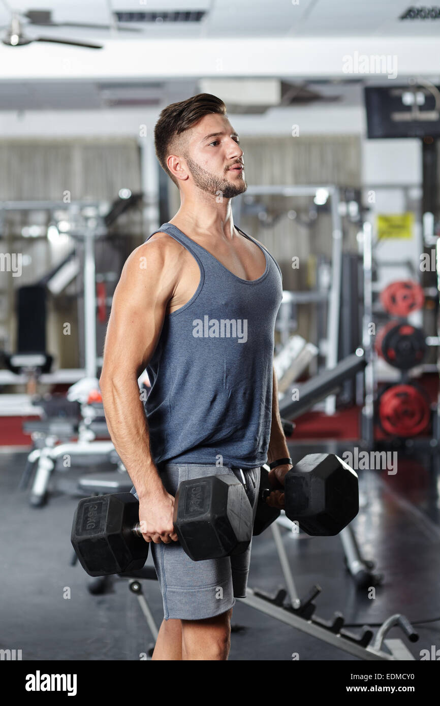 Strong fit man doing shoulder and trapeze workout with very heavy ...