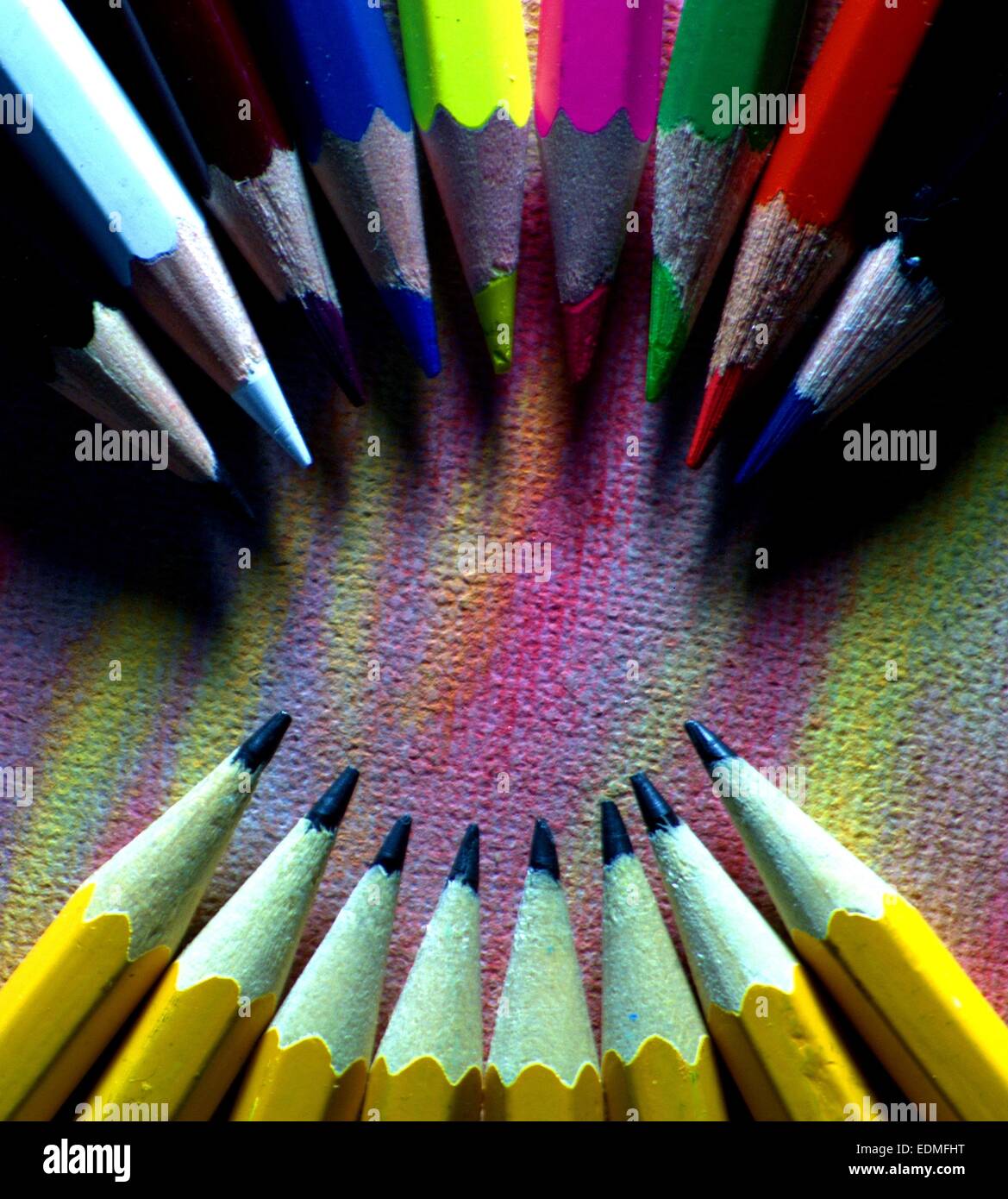 colored pencils in an arc formation facing an arc of regular pencils ...