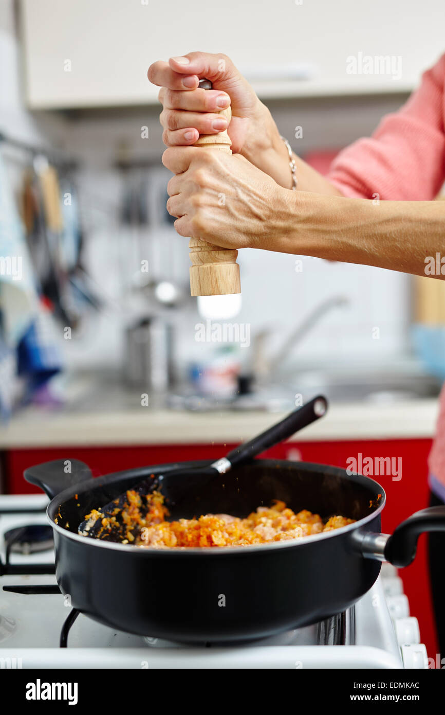 Woman cook grinding pepper over lasagna recipe in a pan Stock Photo - Alamy