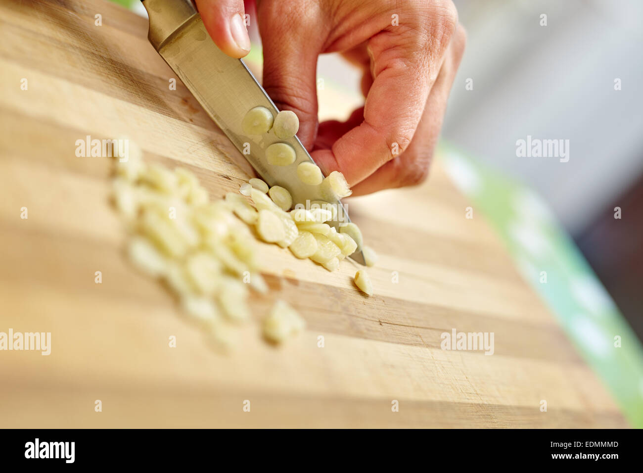 Woman hands chopping garlic on a wooden board Stock Photo - Alamy