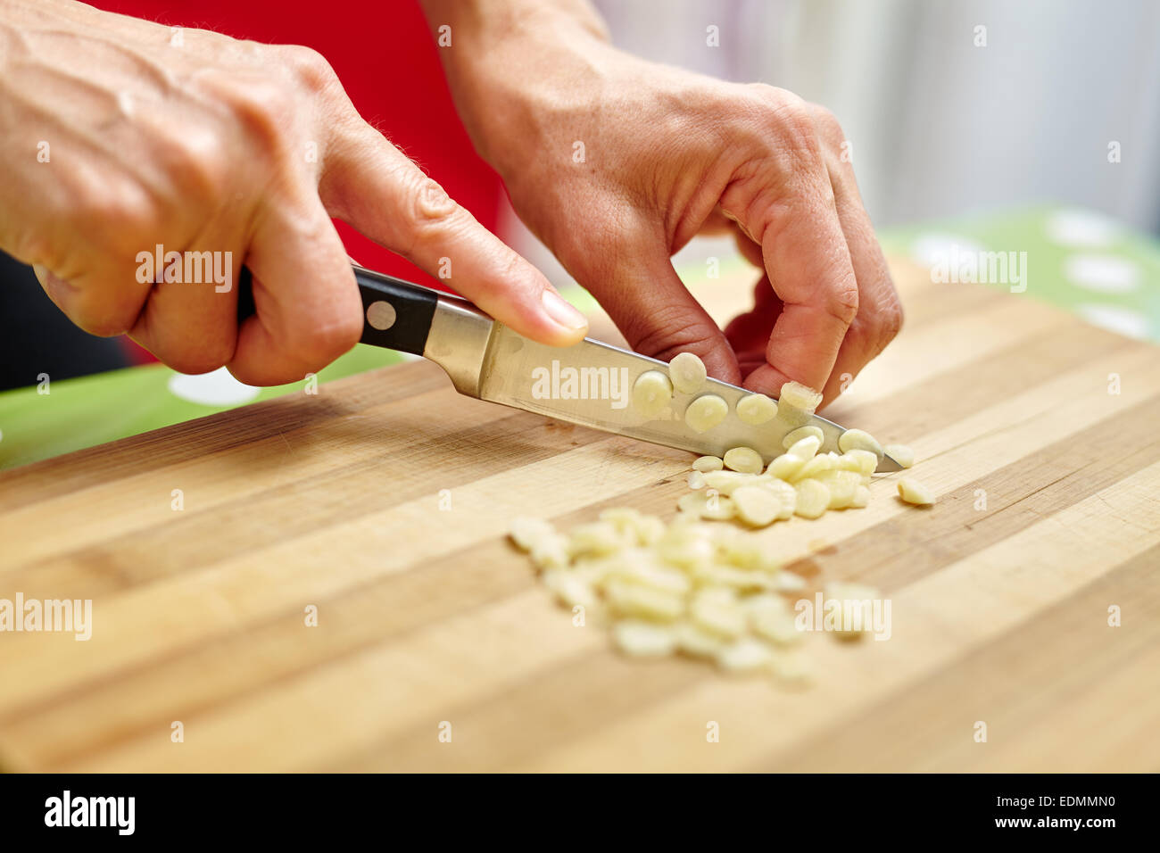 Woman hands chopping garlic on a wooden board Stock Photo - Alamy