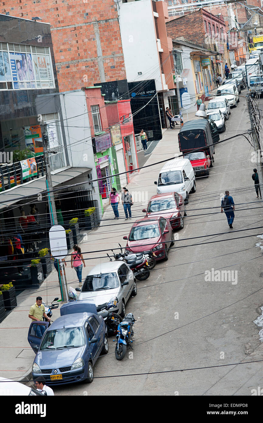 Hilly road with cars parked all the way up on one side. Fusagasuga town ...