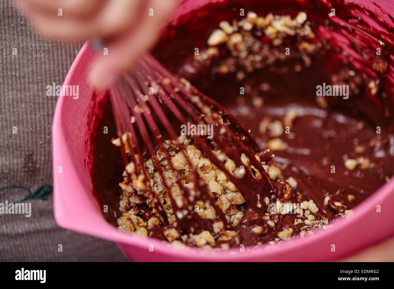 Woman whisking in a bowl chocolate cream and ground walnuts for a ...