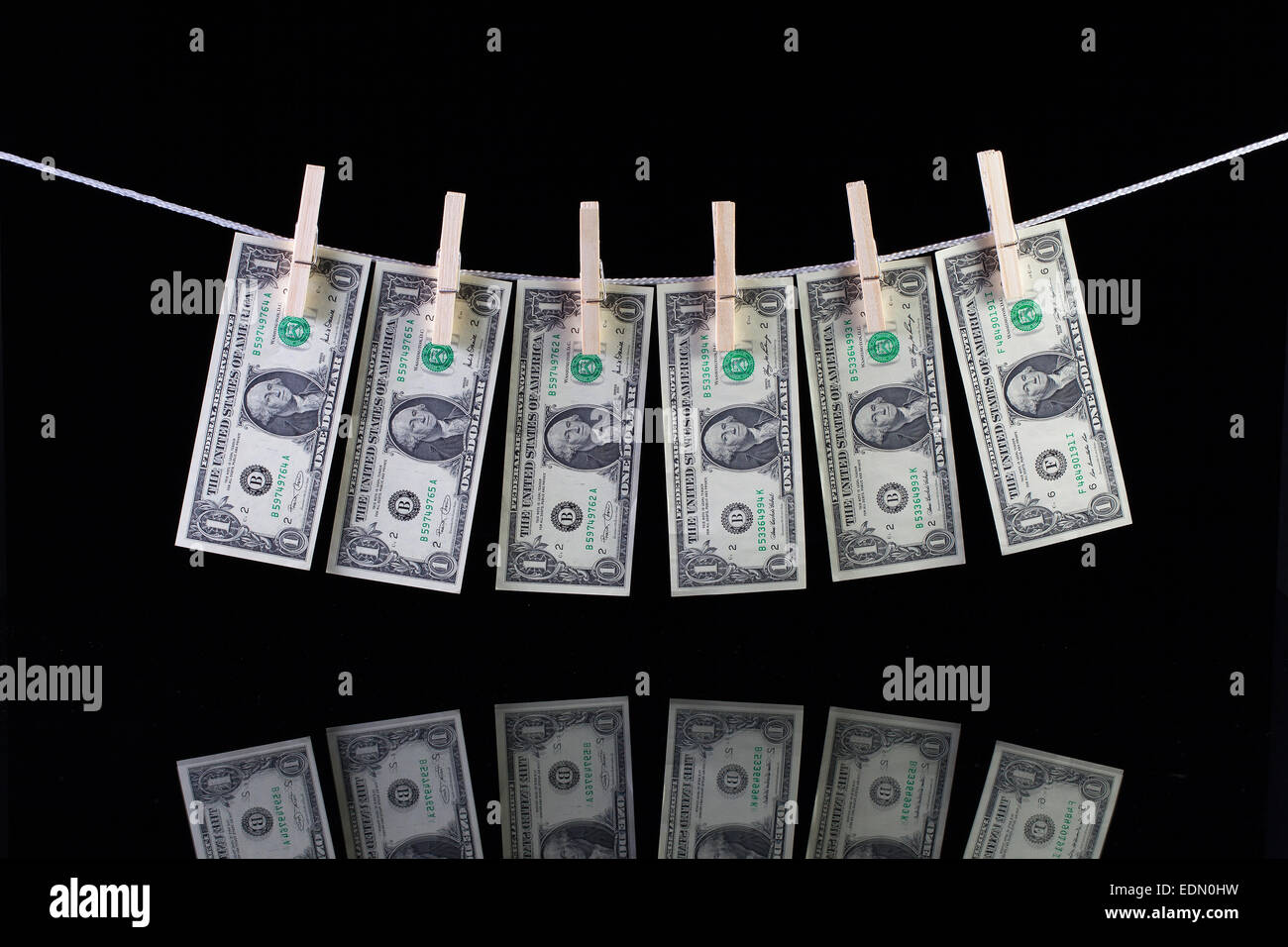 Dirty US dollar banknotes hanging from a clothesline and reflecting in ...