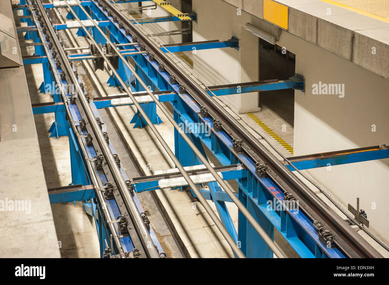 Railway tracks at a sloping underground metro train station platform ...
