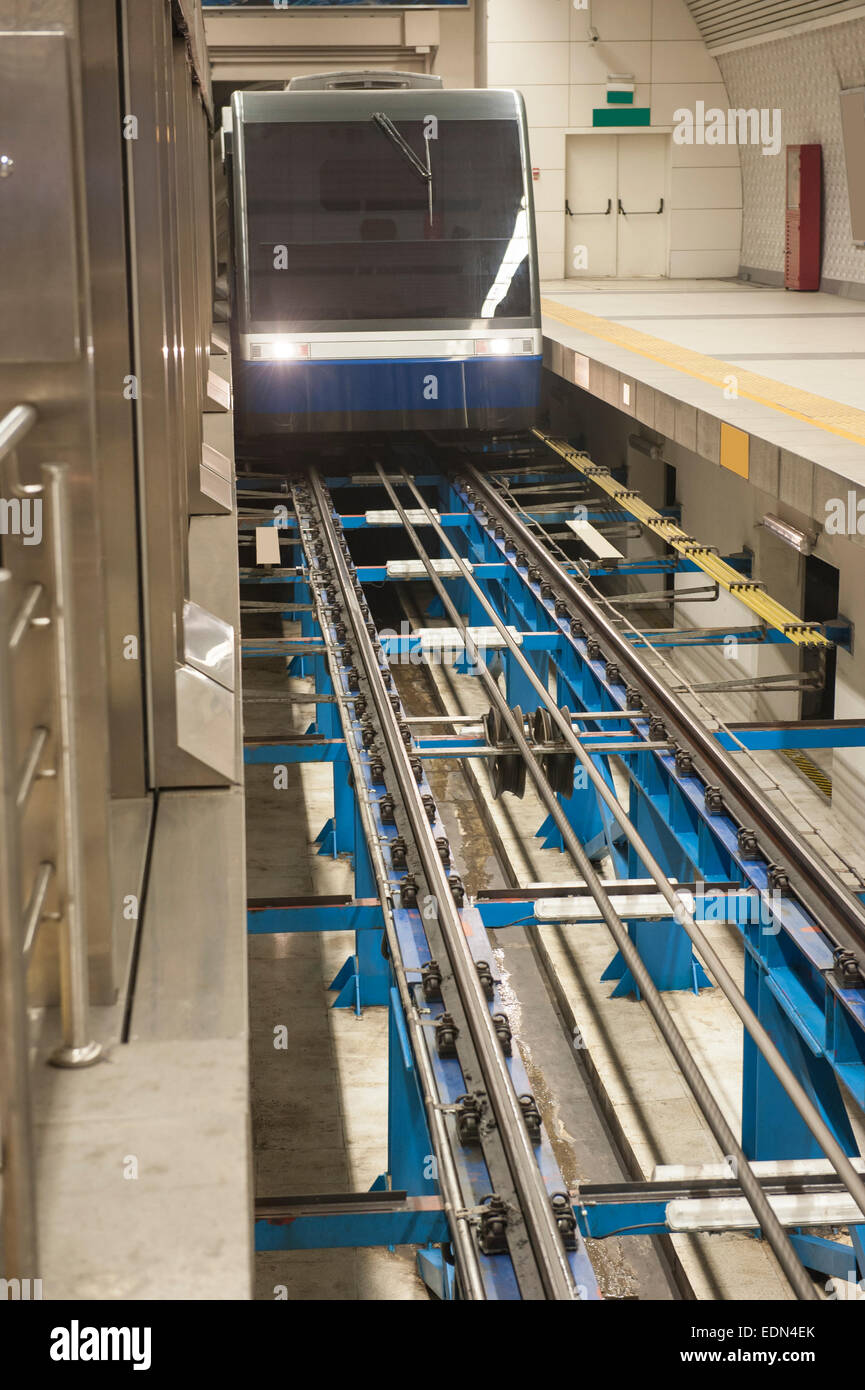 Railway tracks at a sloping underground metro train station platform ...