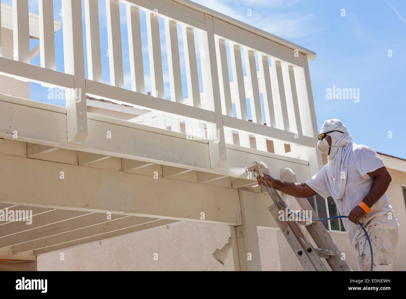 House Painter Wearing Facial Protection Spray Painting A Deck of A Home ...