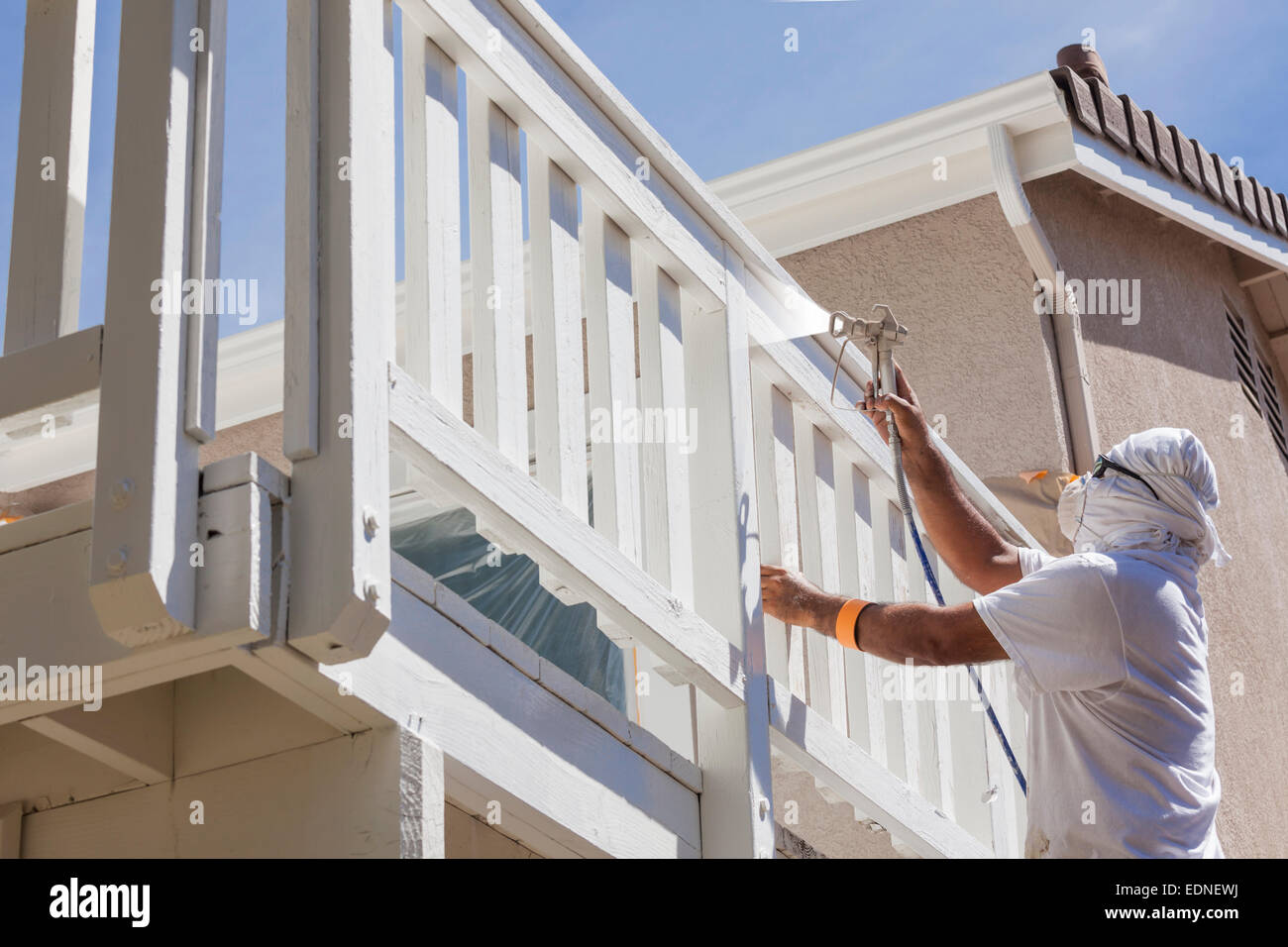 House Painter Wearing Facial Protection Spray Painting A Deck of A Home ...