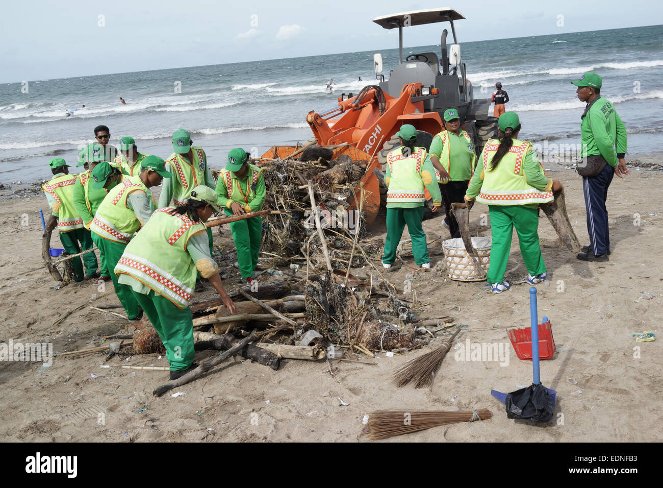 Janitor cleaning up trash in Kuta Beach, Bali Indonesia. Kuta is one of ...