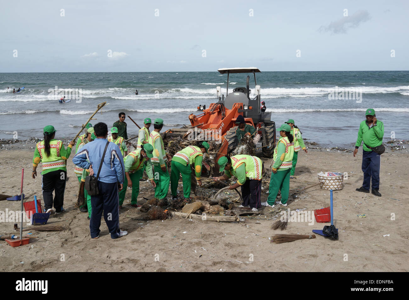 Janitor cleaning up trash in Kuta Beach, Bali Indonesia. Kuta is one of ...
