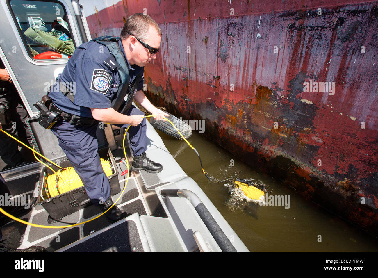 US Customs and Border Protection Officer checks a ship below the water ...