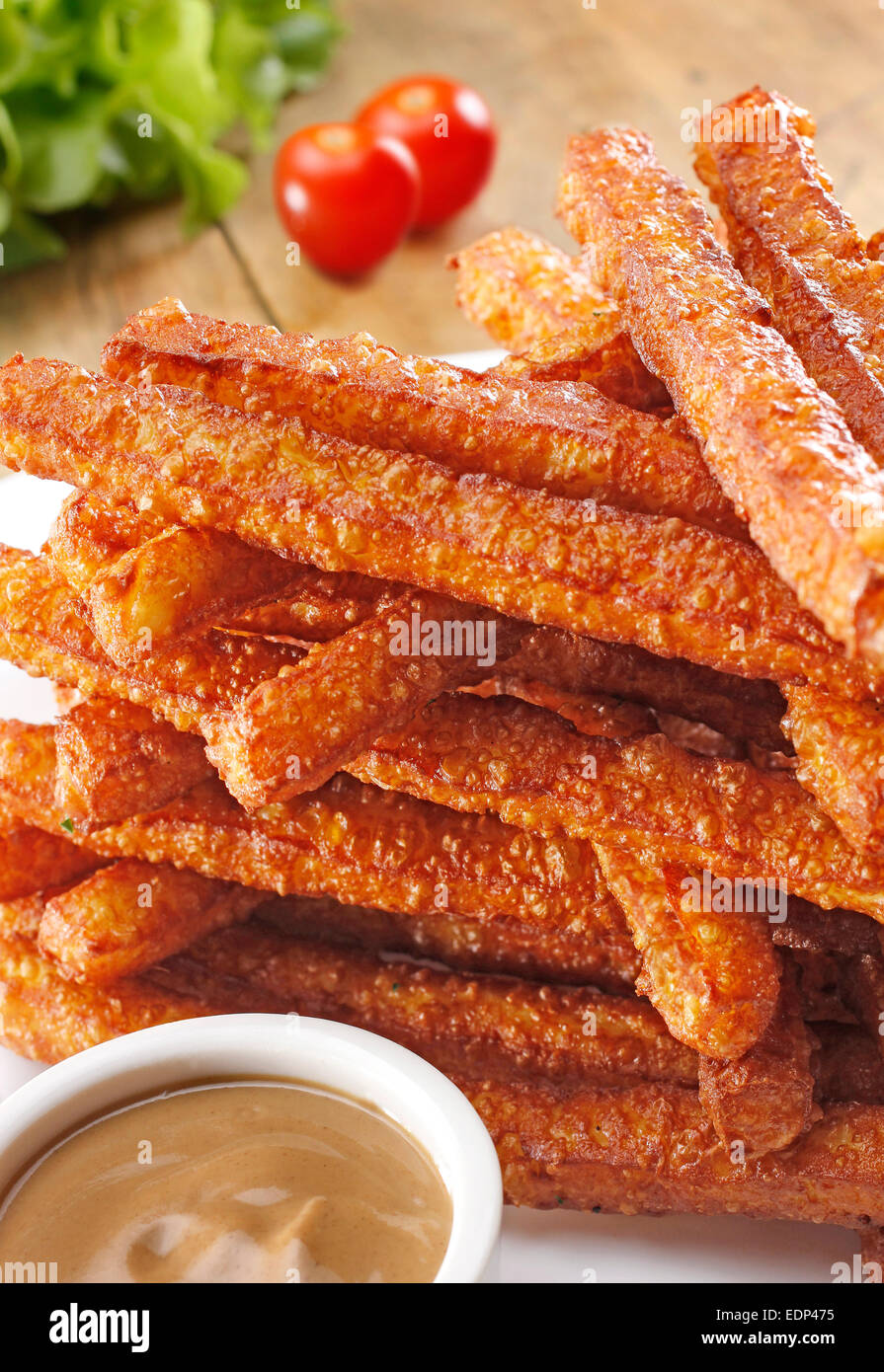 A close up shot of fried cheese sticks with salad and dipping sauce ...