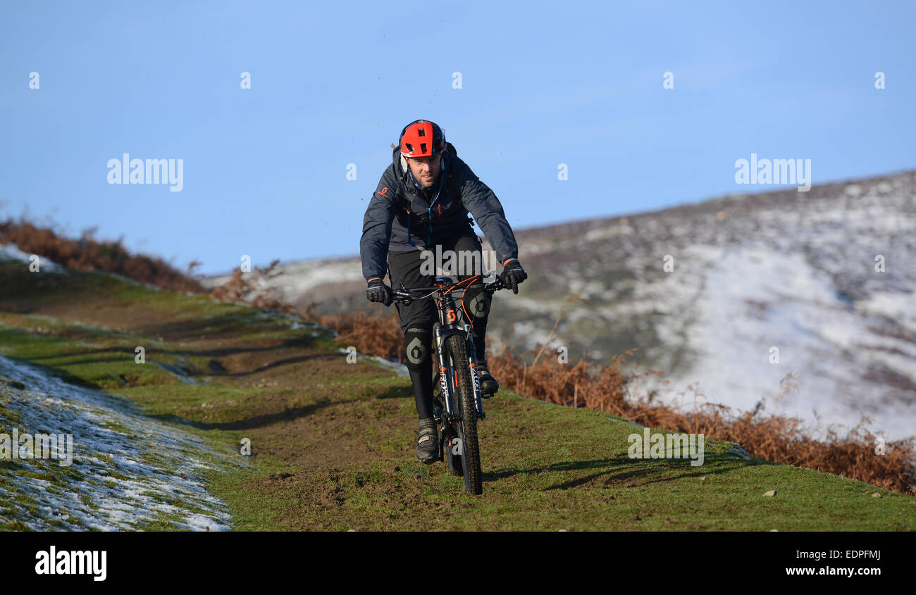 Mountain biker biking bike cycling in winter on the Long Mynd ...