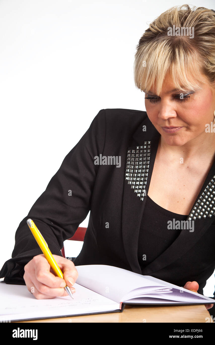 Studio portrait of a cute blond girl writing Stock Photo - Alamy