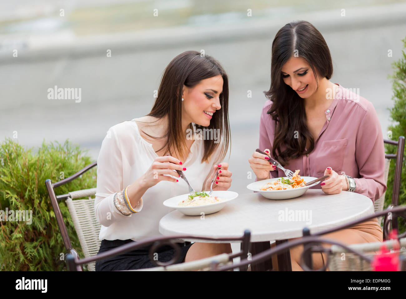 Pretty young women having lunch in the restaurant Stock Photo - Alamy
