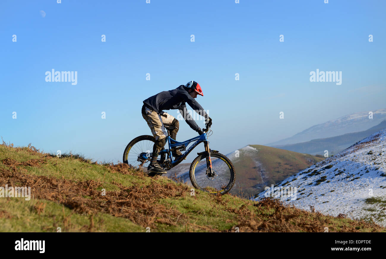 Mountain biker biking bike cycling in winter on the Long Mynd ...