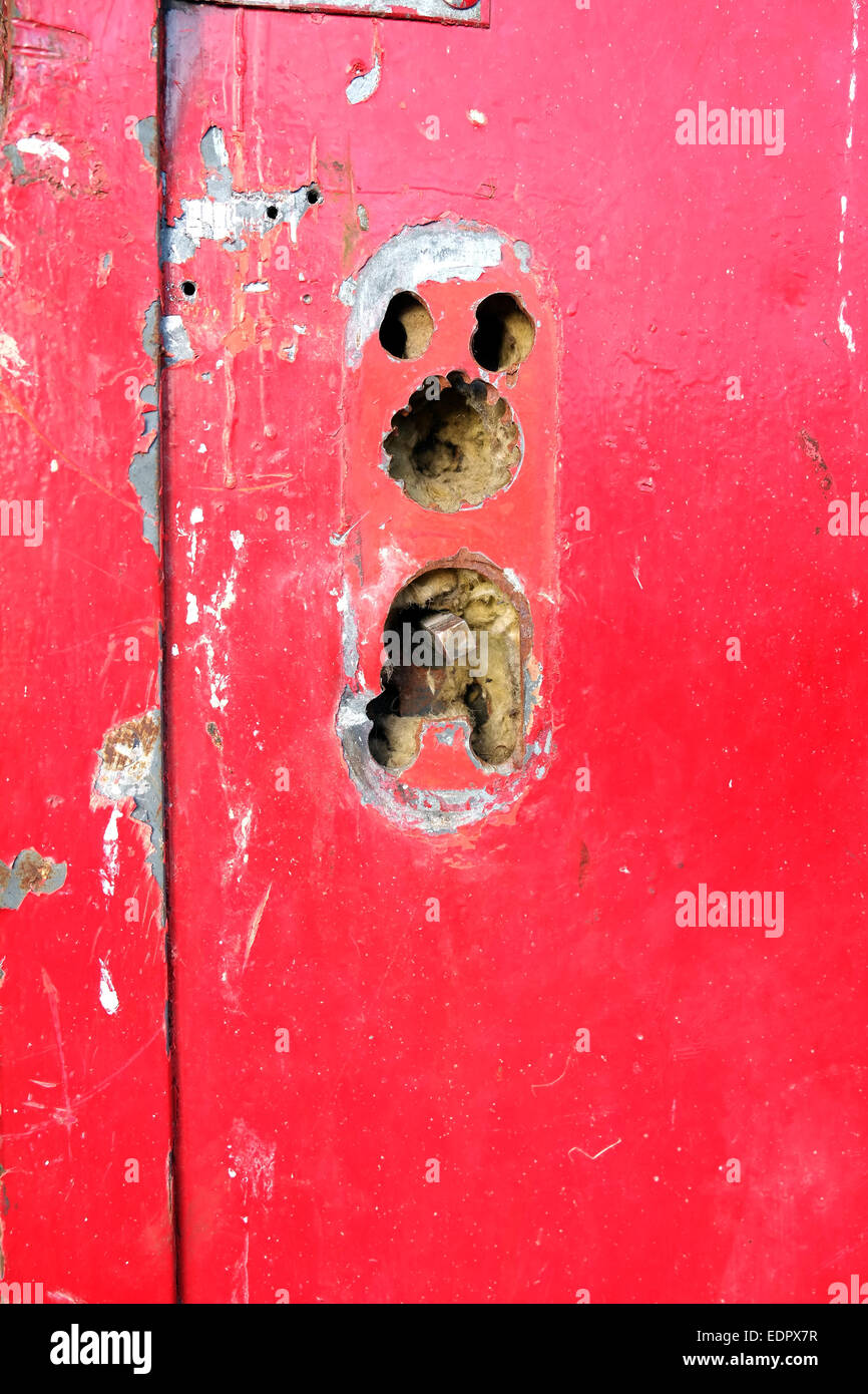 Red steel doors to a supermarket damaged by criminals trying the break ...
