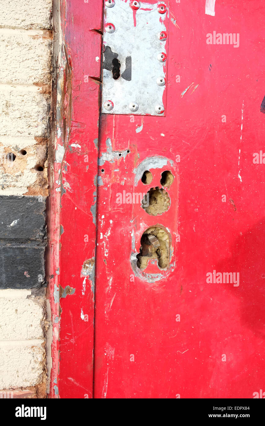Red steel doors to a supermarket damaged by criminals trying the break ...