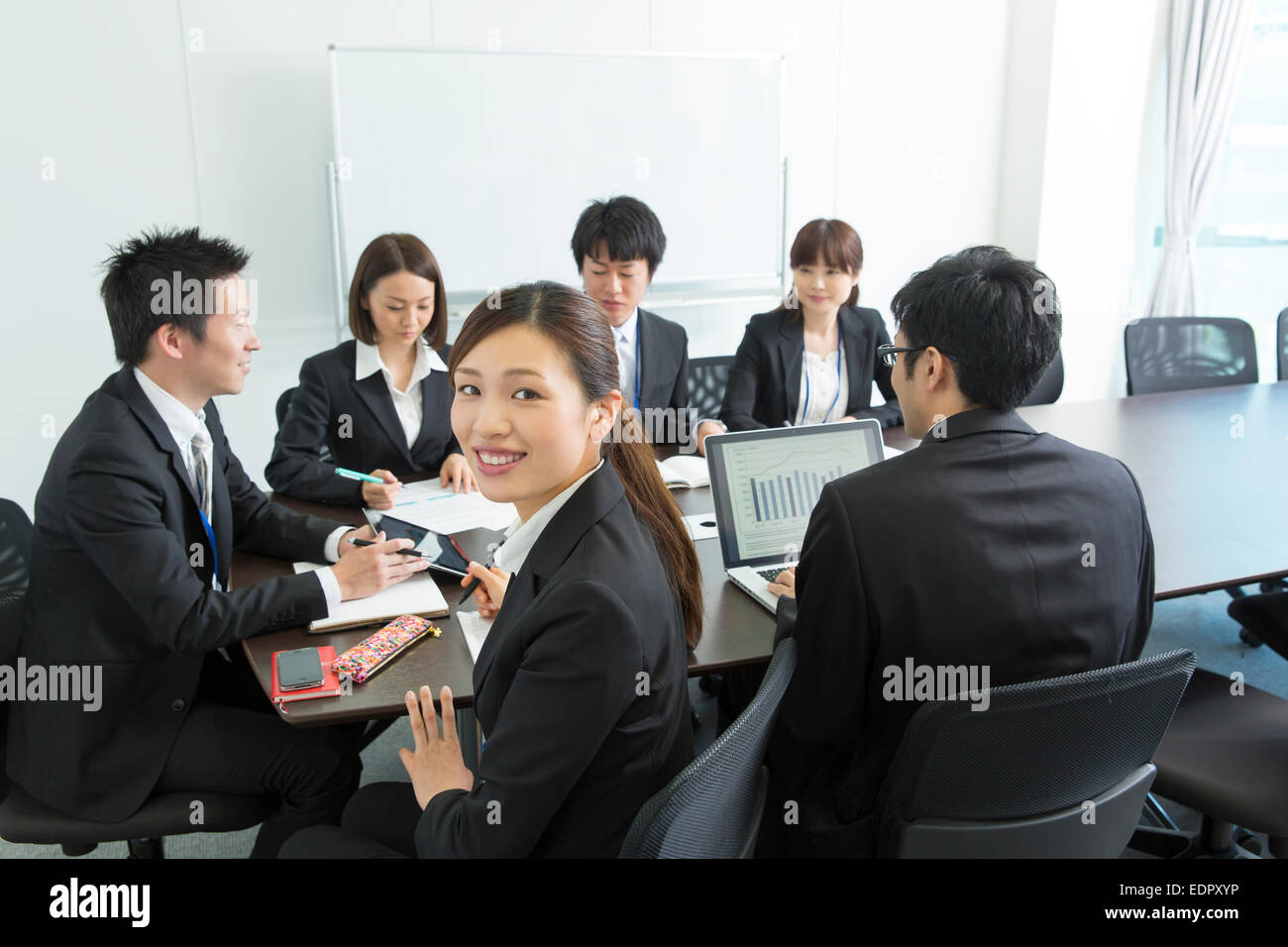 Business People in Meeting and A Woman Looking Back Stock Photo - Alamy