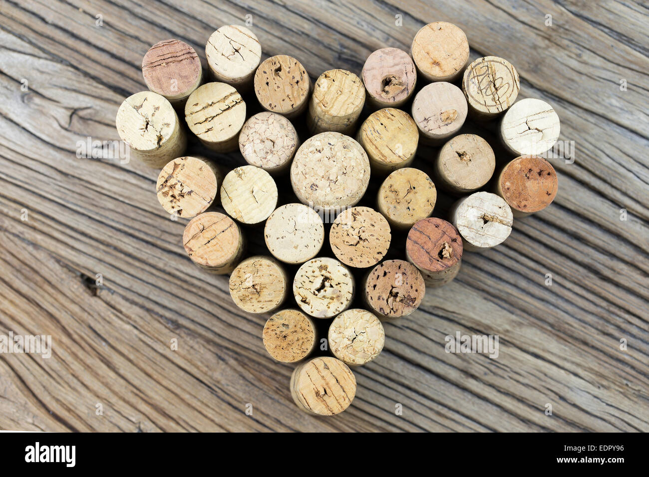 Wine corks form a heart shape image on the middle of wood board ...