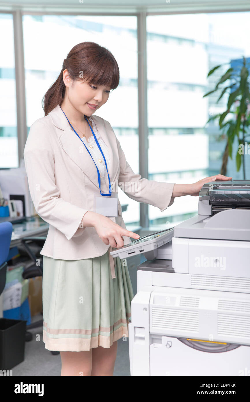 Businesswoman Using Copier Machine Stock Photo - Alamy