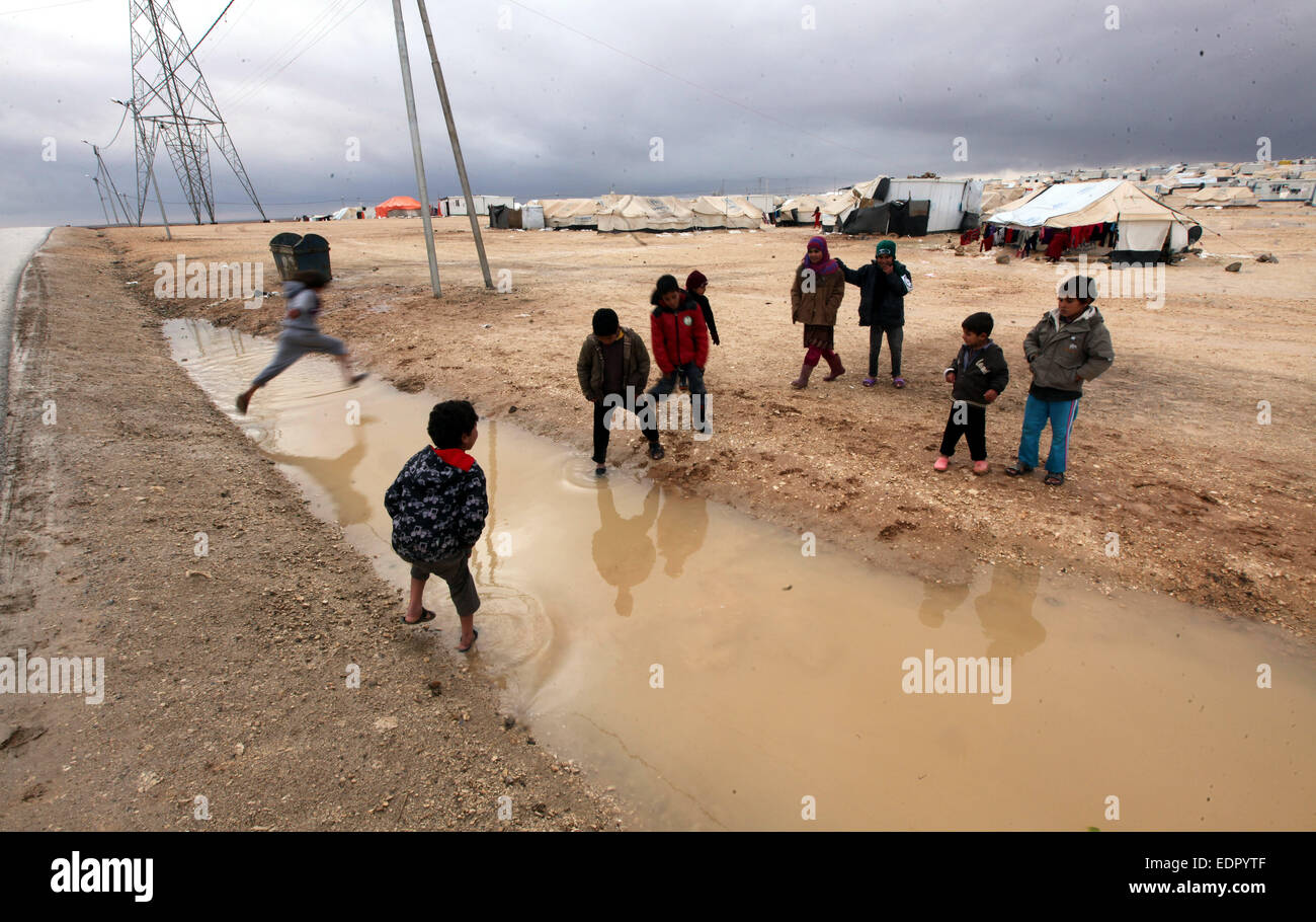Amman. 8th Jan, 2015. Syrian refugee boys cross a puddle at the Zatari ...