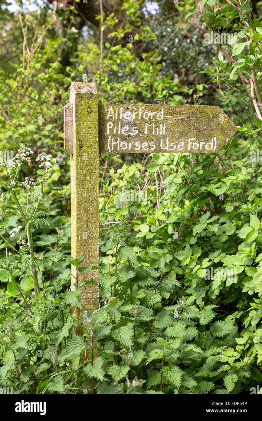 Footpath sign to Allerford and Piles Mill among nettles in Exmoor ...